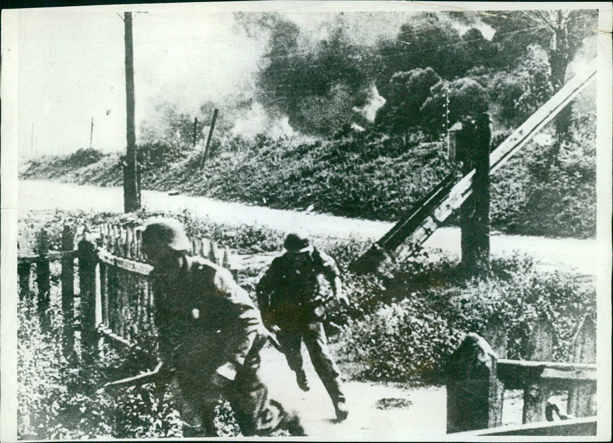 Two German soldiers dash for safety from an oil well explosion - Vinta