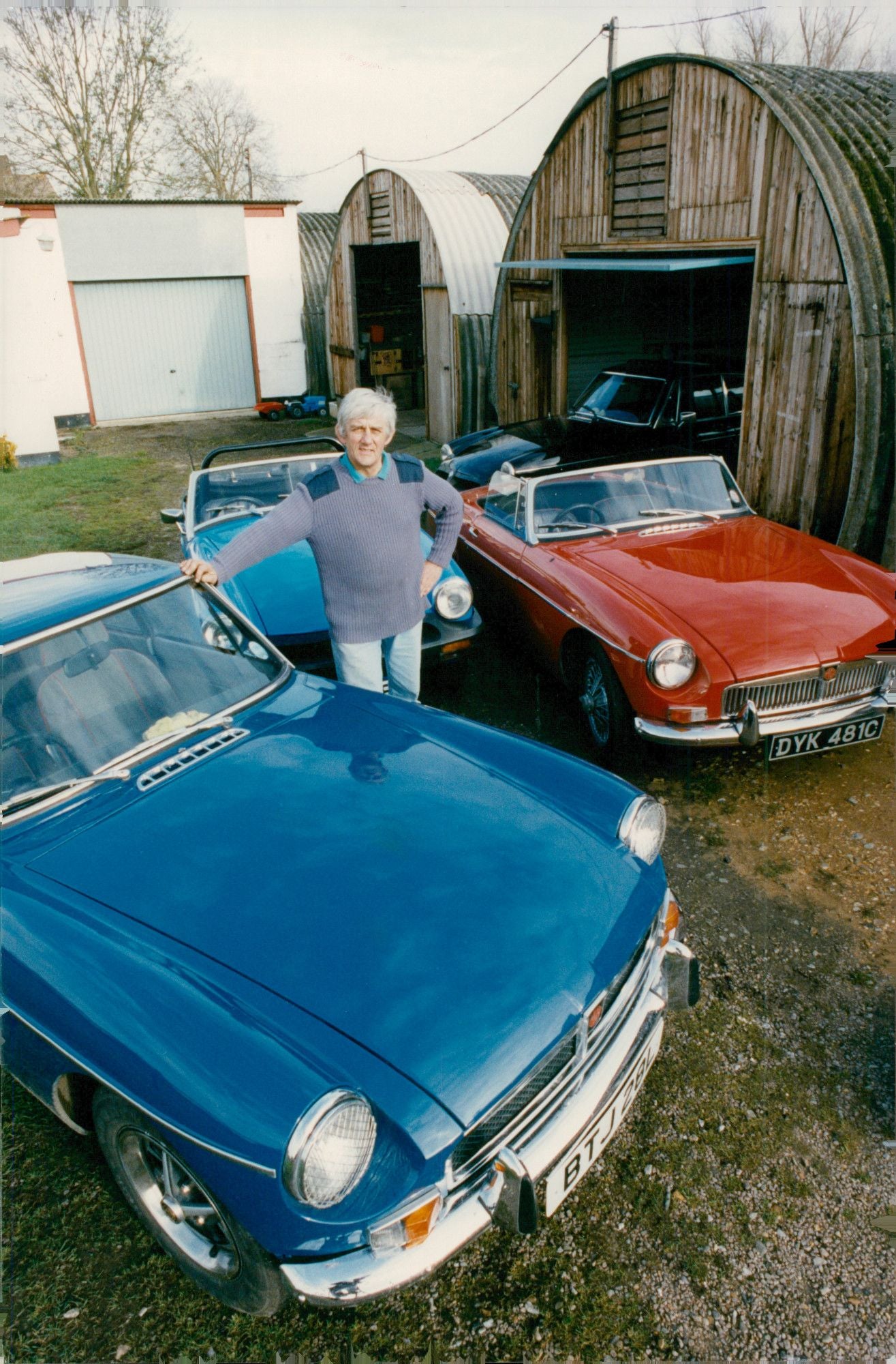 JOHN RUSH WITH SOME OF THE MG SPORTS CARS HE HAS RESTORED AT HIS WORKS