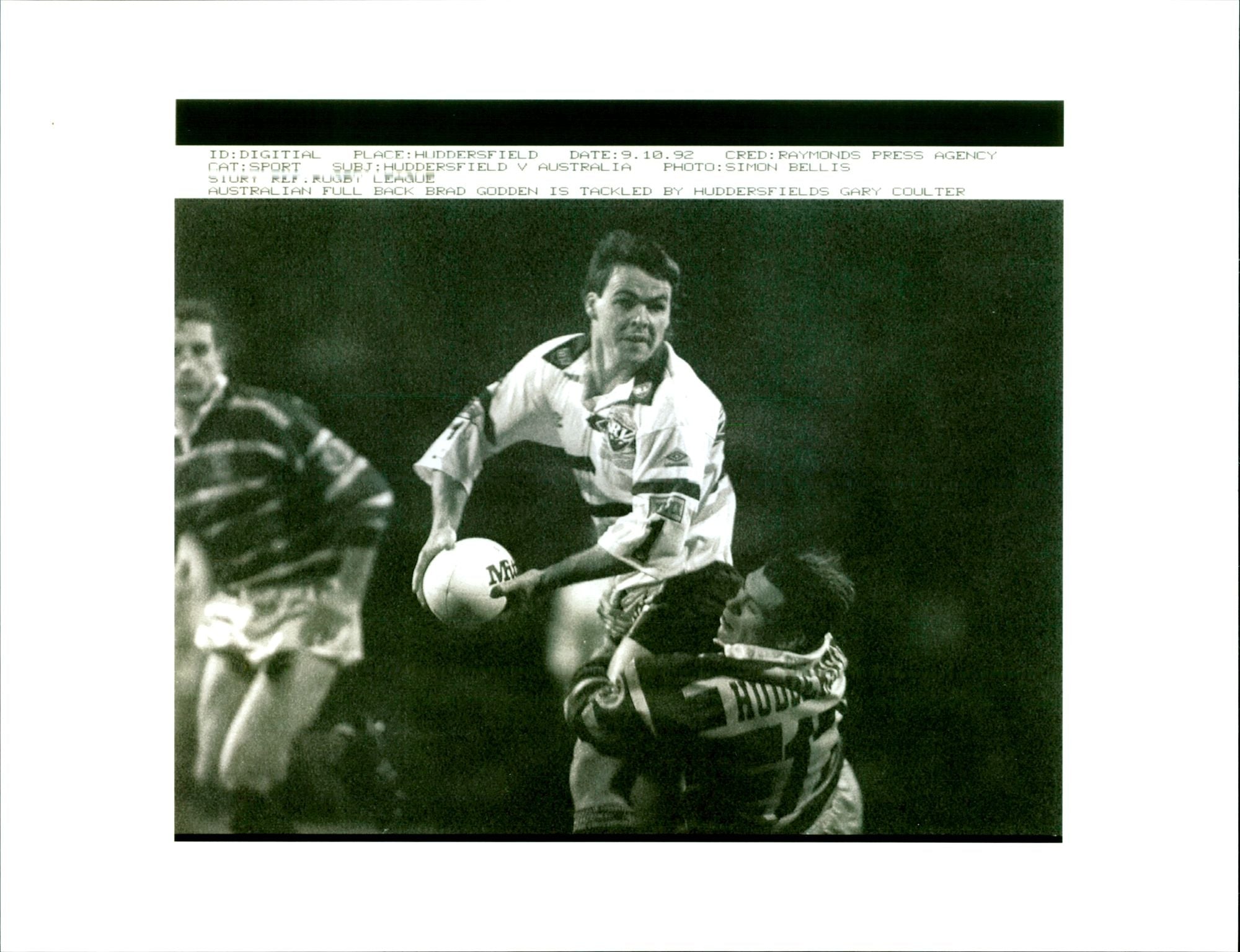 Australian fullback Brad Godden is tackled by Huddersfield's Gary Coul