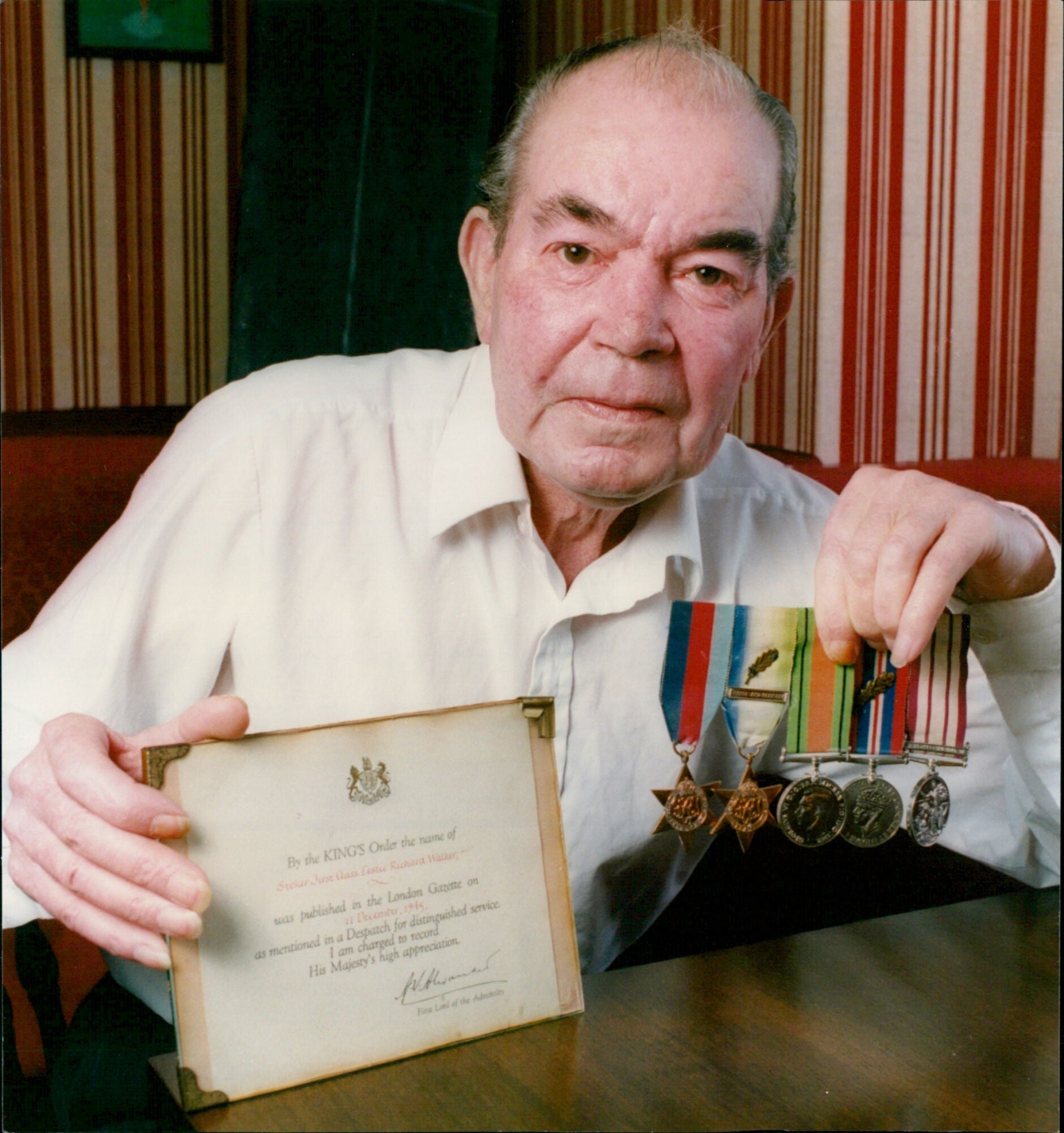 Les Walker proudly displays his campaign medals and citation from King