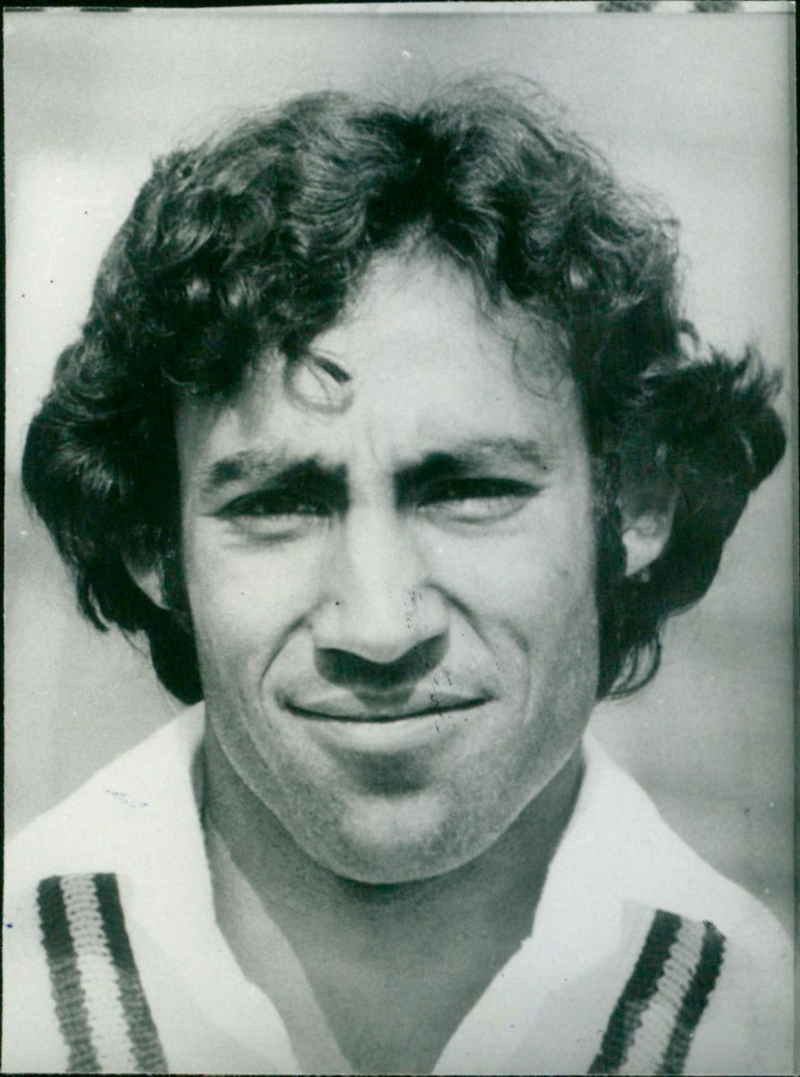 Pakistani cricketer Mudassar Nazar holding a newspaper page featuring