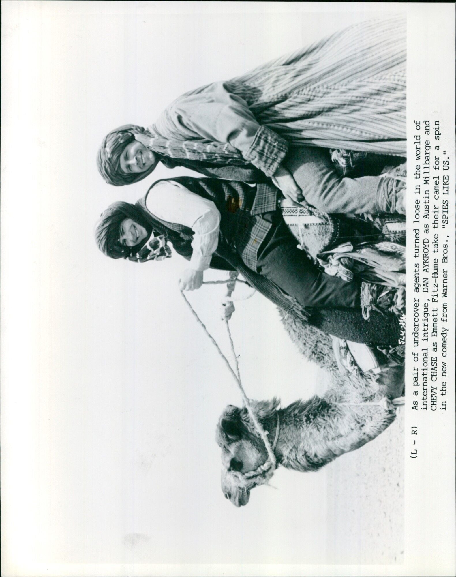 Actors Dan Aykroyd and Chevy Chase take a camel ride in the 1986 comed
