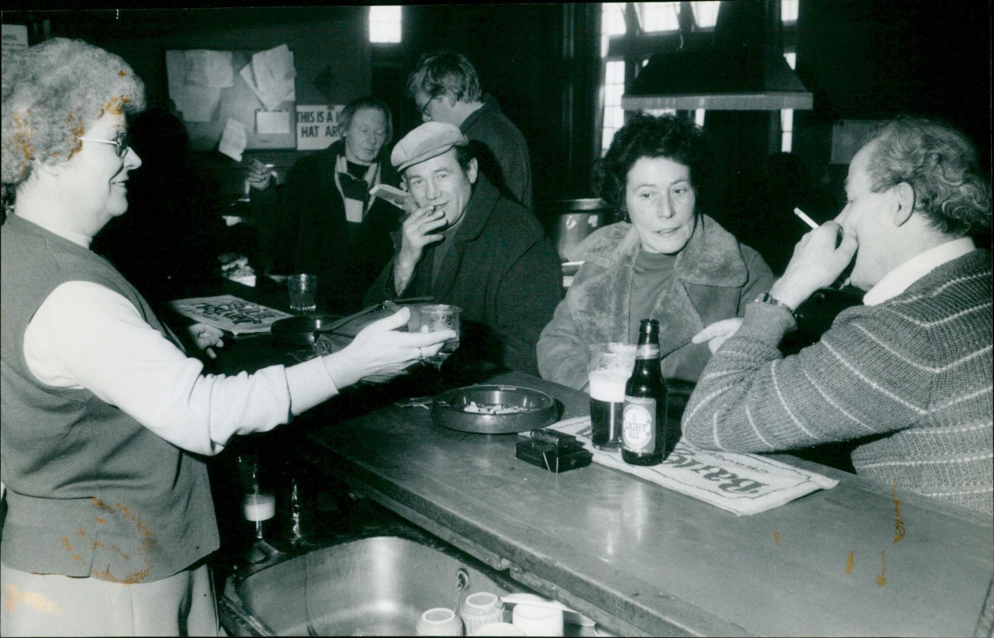 Barmaid Win Beynon chats with patrons Bill Nagy and George Stone and h