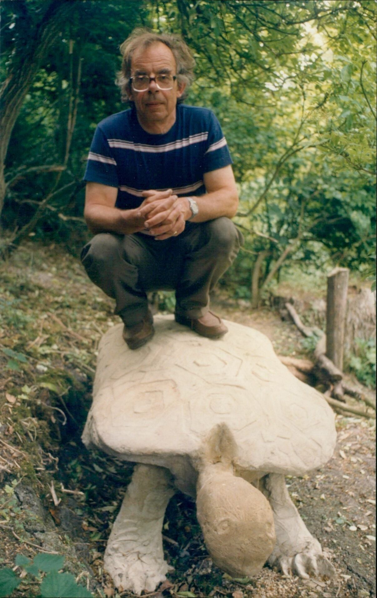Dr Michael Shone walking with Capria, a concrete statue of a giant tor