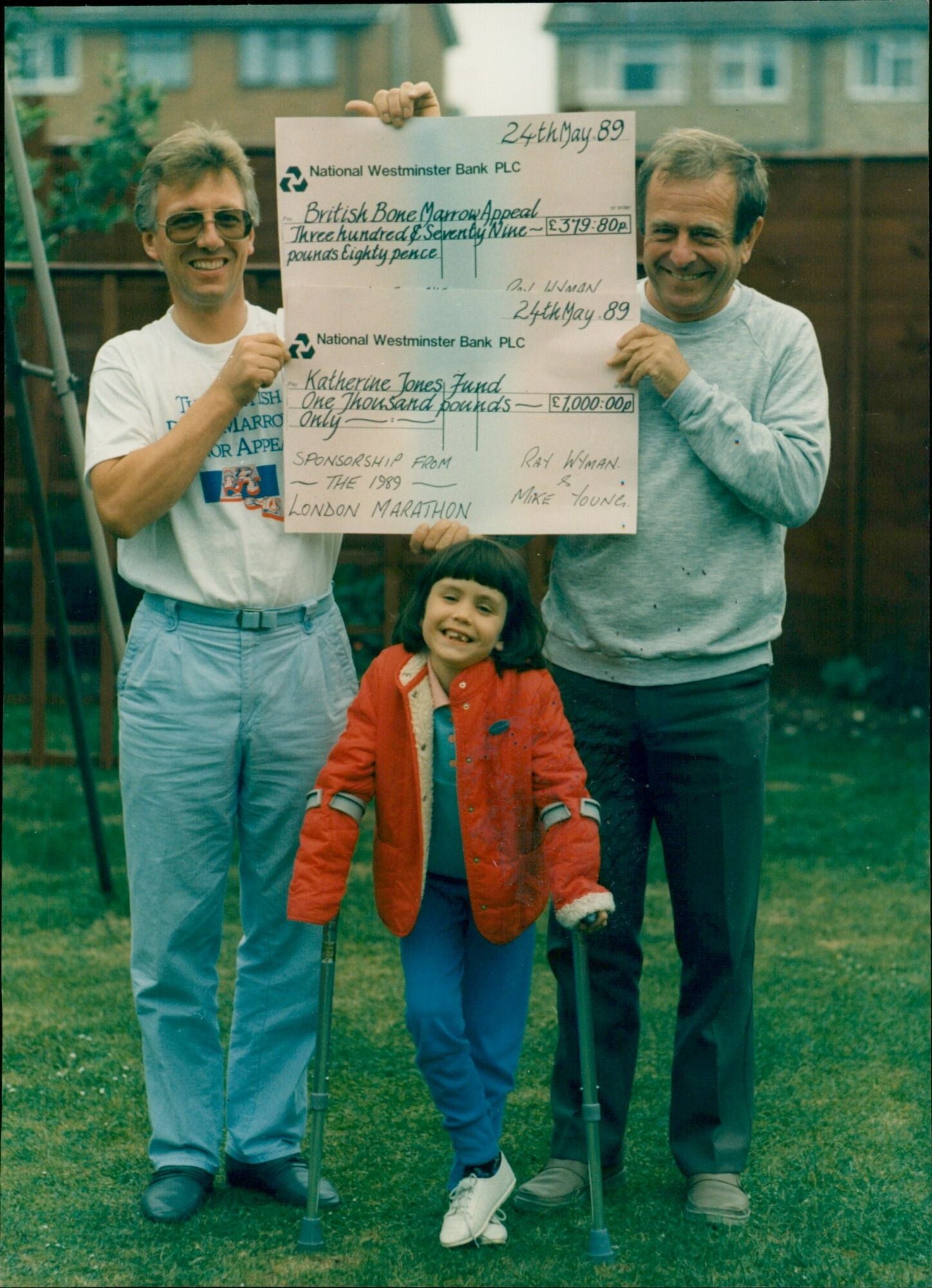 Eight-year-old Katherine Jones receives a cheque from Mike Young and R