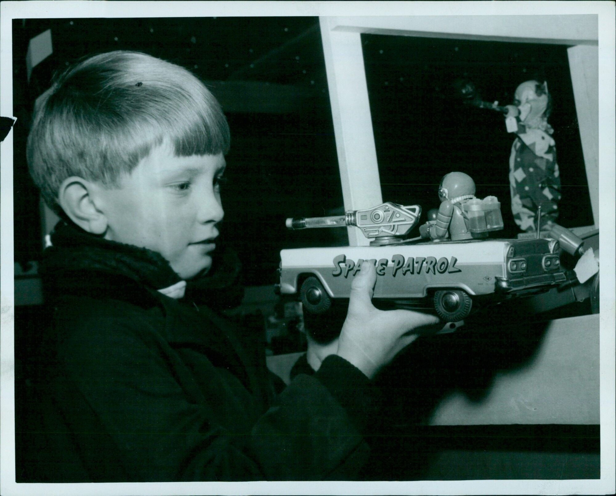 Nine-year-old Nicholas Forder looks at a Space Patrol toy car. - Vinta