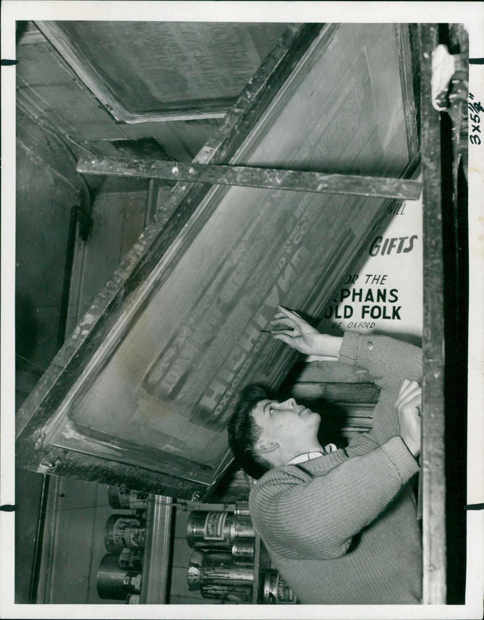 John Wardrop, an apprentice of Mr. Milton, works on a silk screen fram
