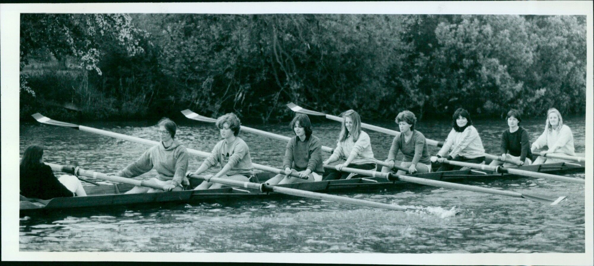 A group of local residents walking in front of a mural of the Magnut 9