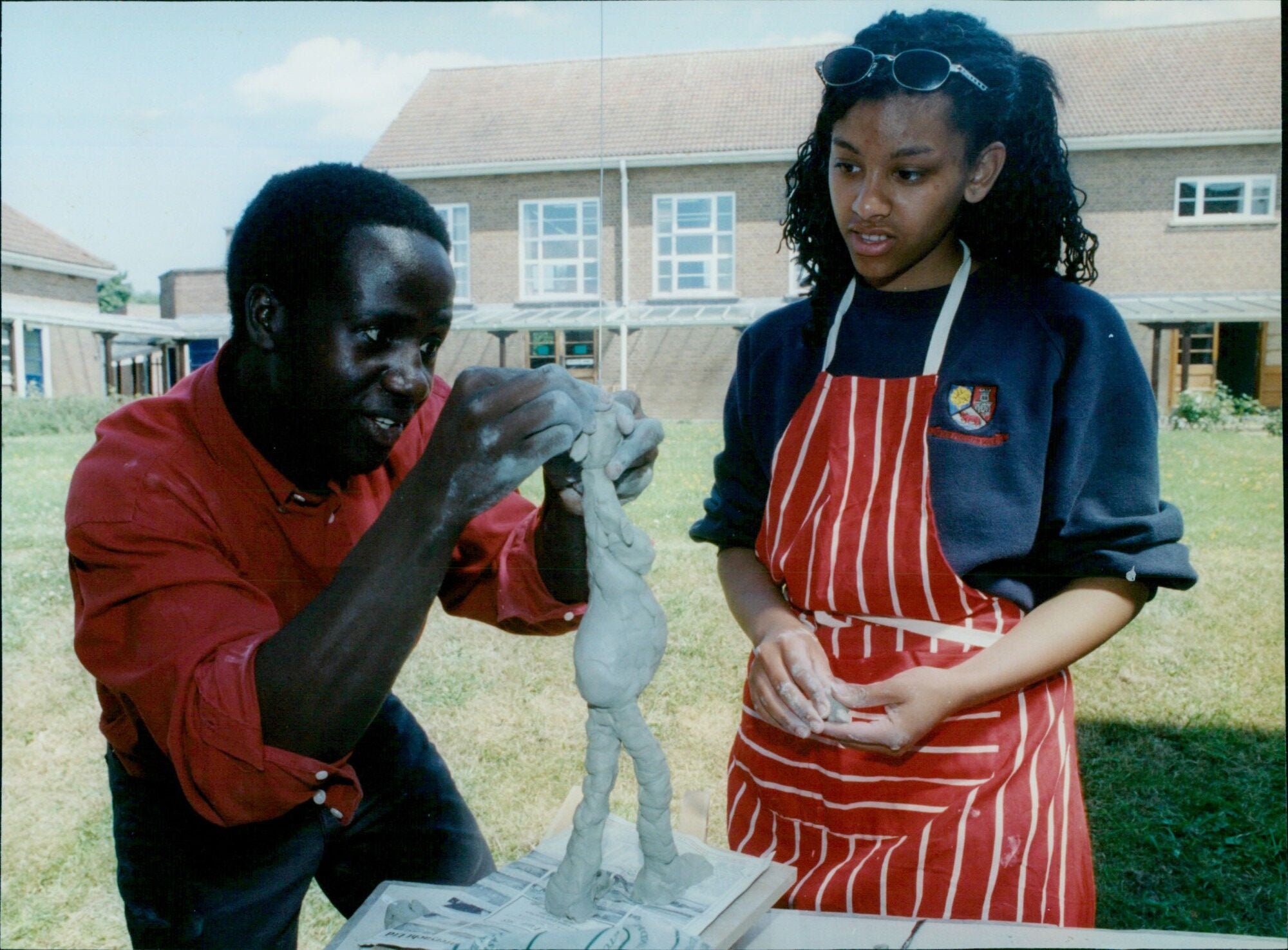 Sculptor David Odwar assists pupils Jade Gabbidon and Jodian LaBeach a