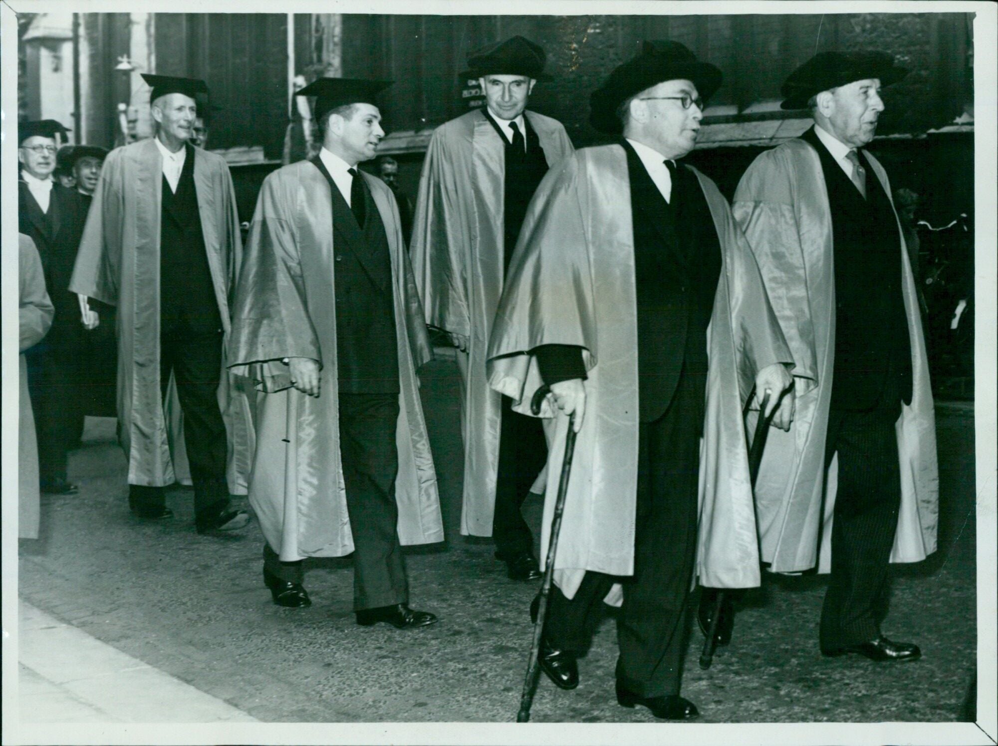Five distinguished dignitaries walking in procession at the Sheldonian