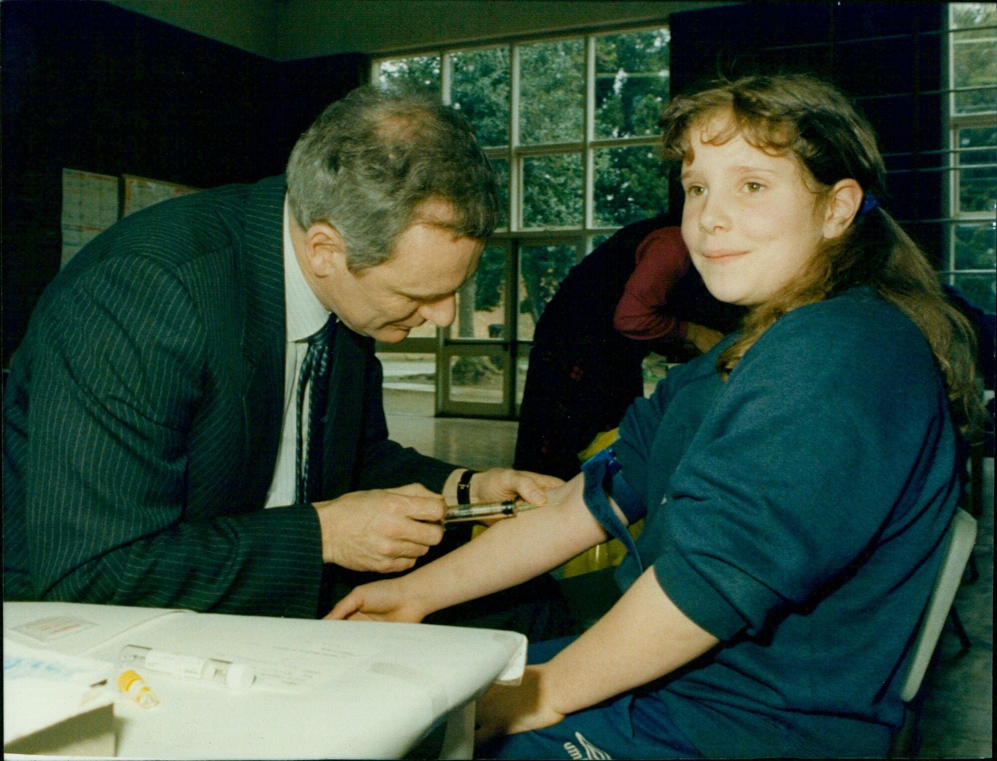 Dr. David Dee takes a blood sample from ten-year-old Sophie Griffin in